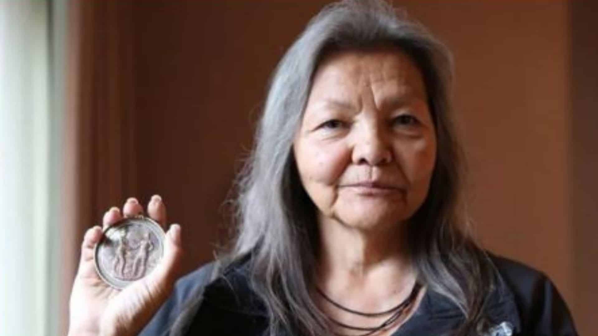 Liz Logan holding Treaty medallion – Energeticcity.ca